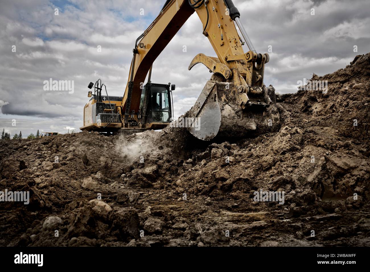 An excavator digging into the ground with its large bucket Stock Photo ...