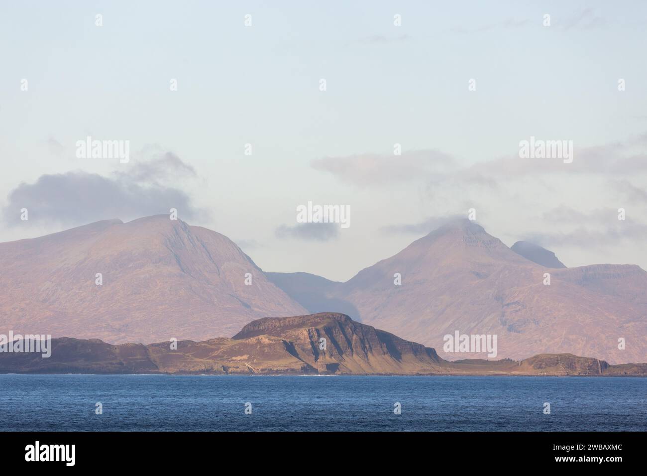 The small island of Muck with the mountains of the Isle of Rum seen ...