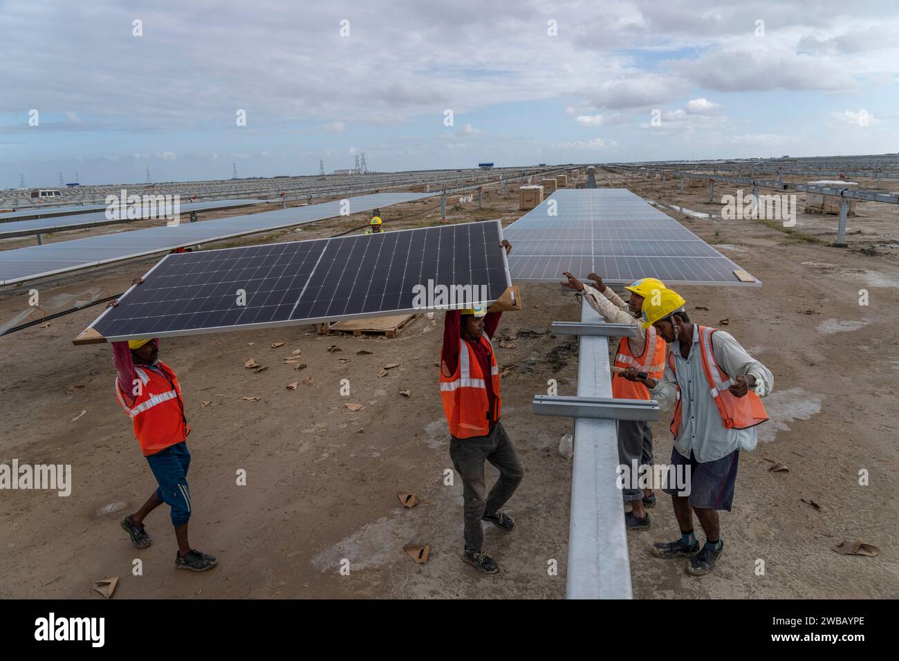 Workers install solar panels at the under-construction Adani Green Energy Limited's Renewable ...