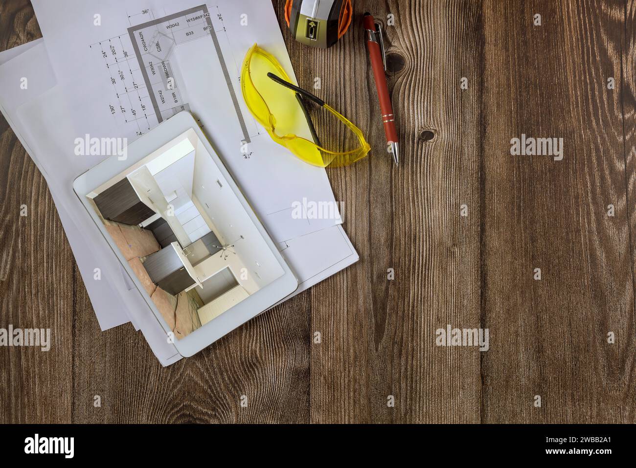 On table, an architectural engineer is designing blueprint for ...