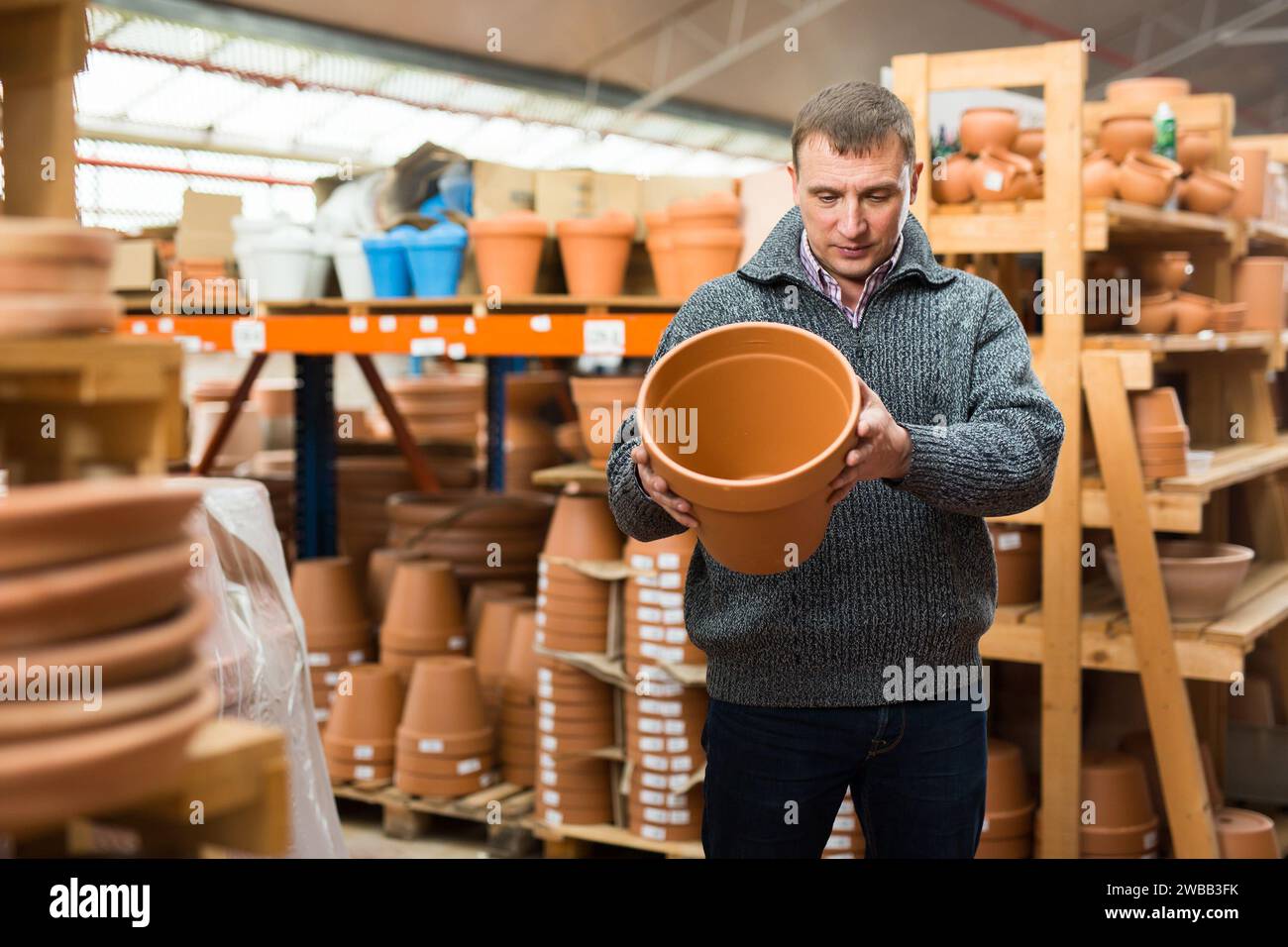 Greenhouse owner choosing plant pots Stock Photo - Alamy
