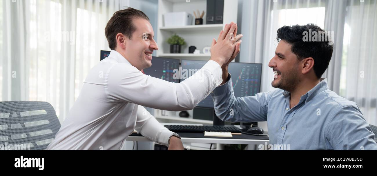 Cheerful two smiling stock traders giving high five on panorama view to ...