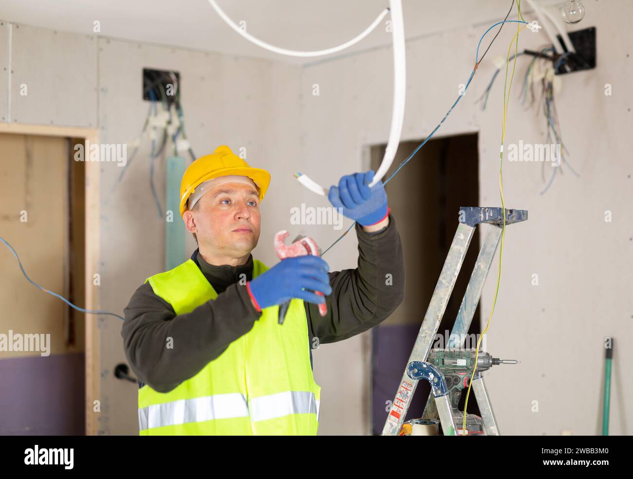 Electrician working with wires in apartment Stock Photo - Alamy