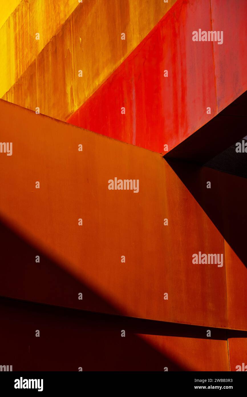 Vivid abstract architectural detail with intersecting red and orange planes creating a dynamic ...