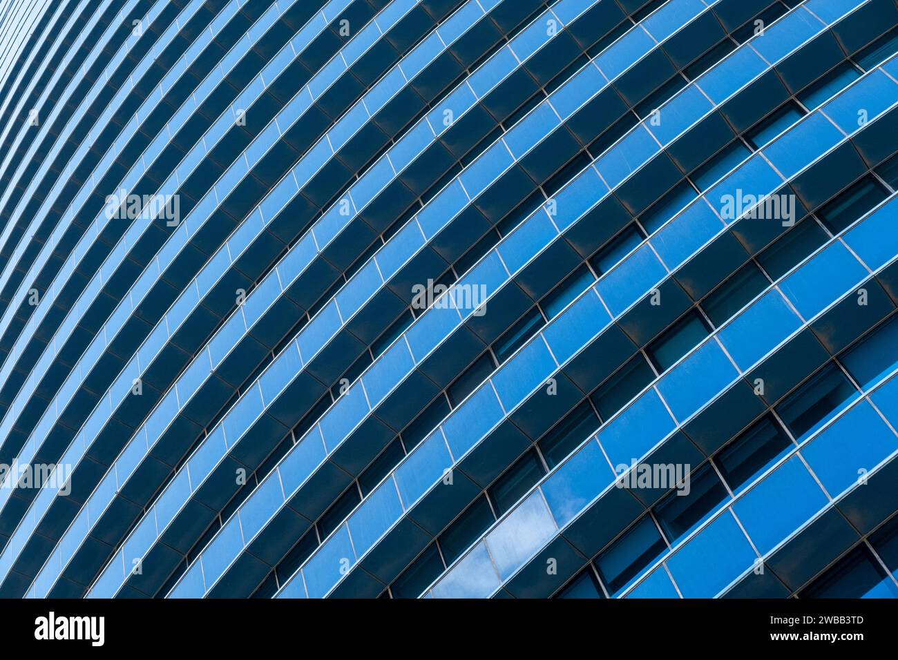 Diagonal intersection of blue glass skyscraper with reflections and ...