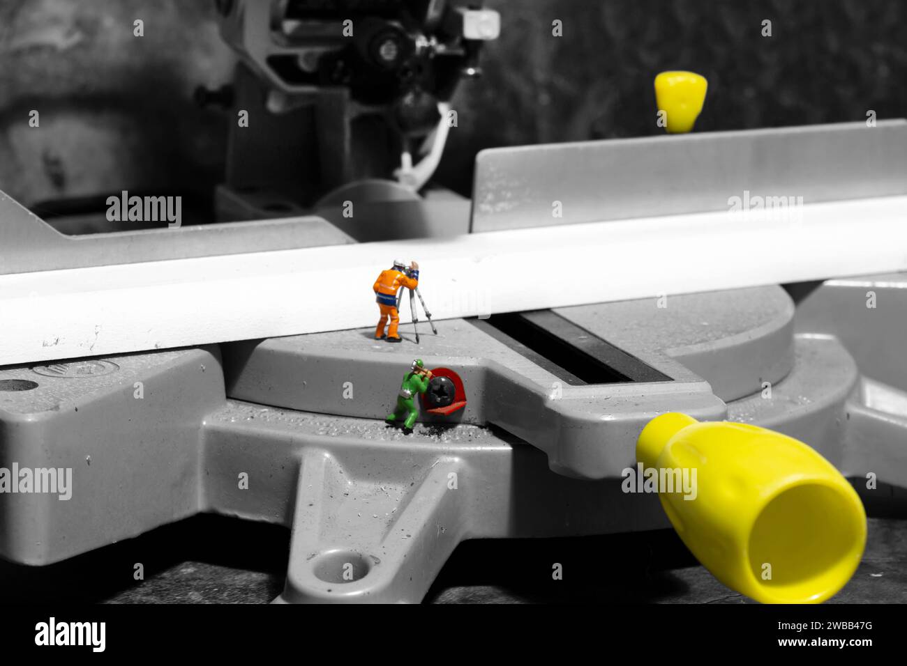 Miniature scale model workers on an electric circular saw. Construction ...