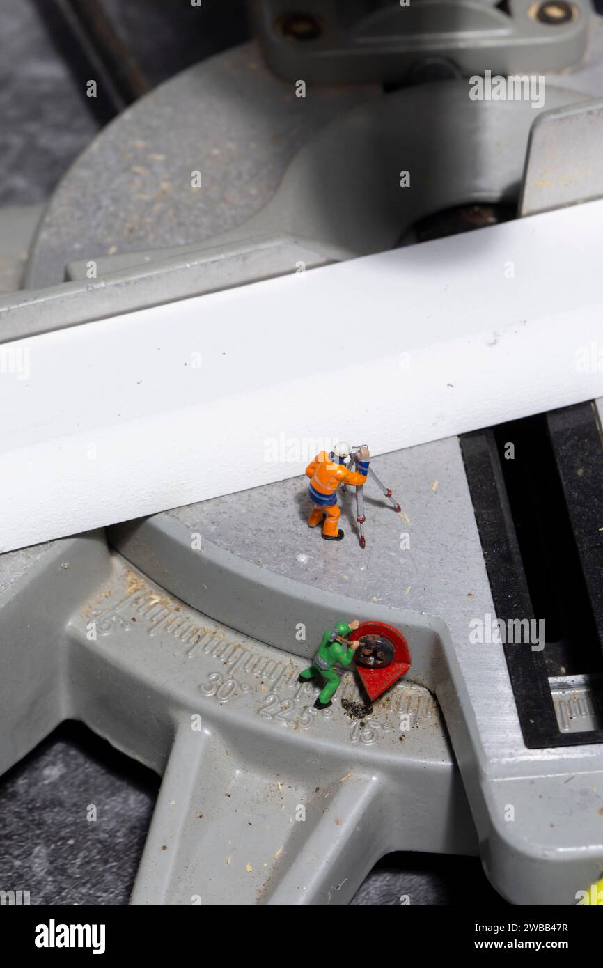 Miniature scale model workers on an electric circular saw. Construction ...