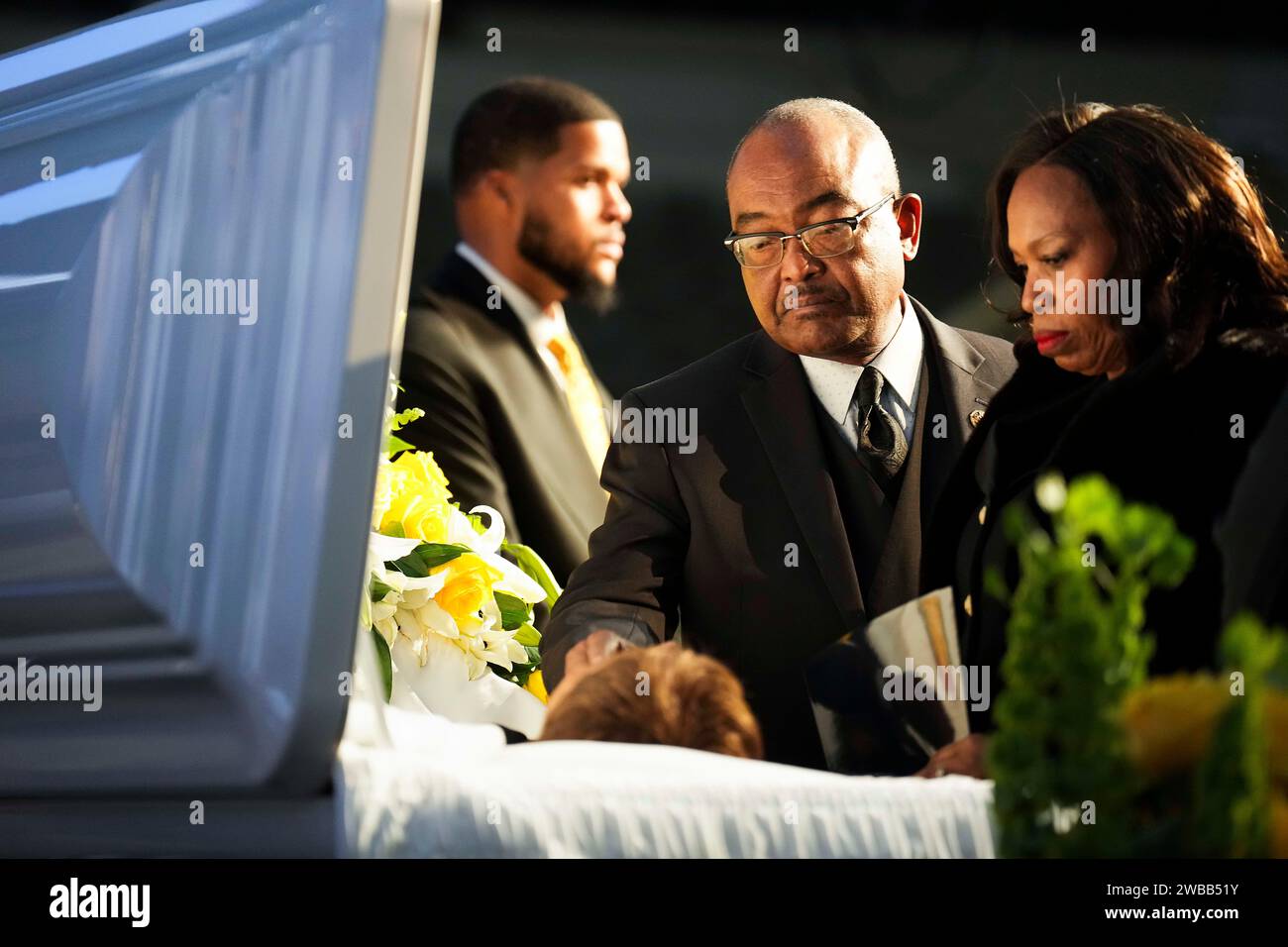 Kirk Johnson reaches into his mother's casket during funeral services ...