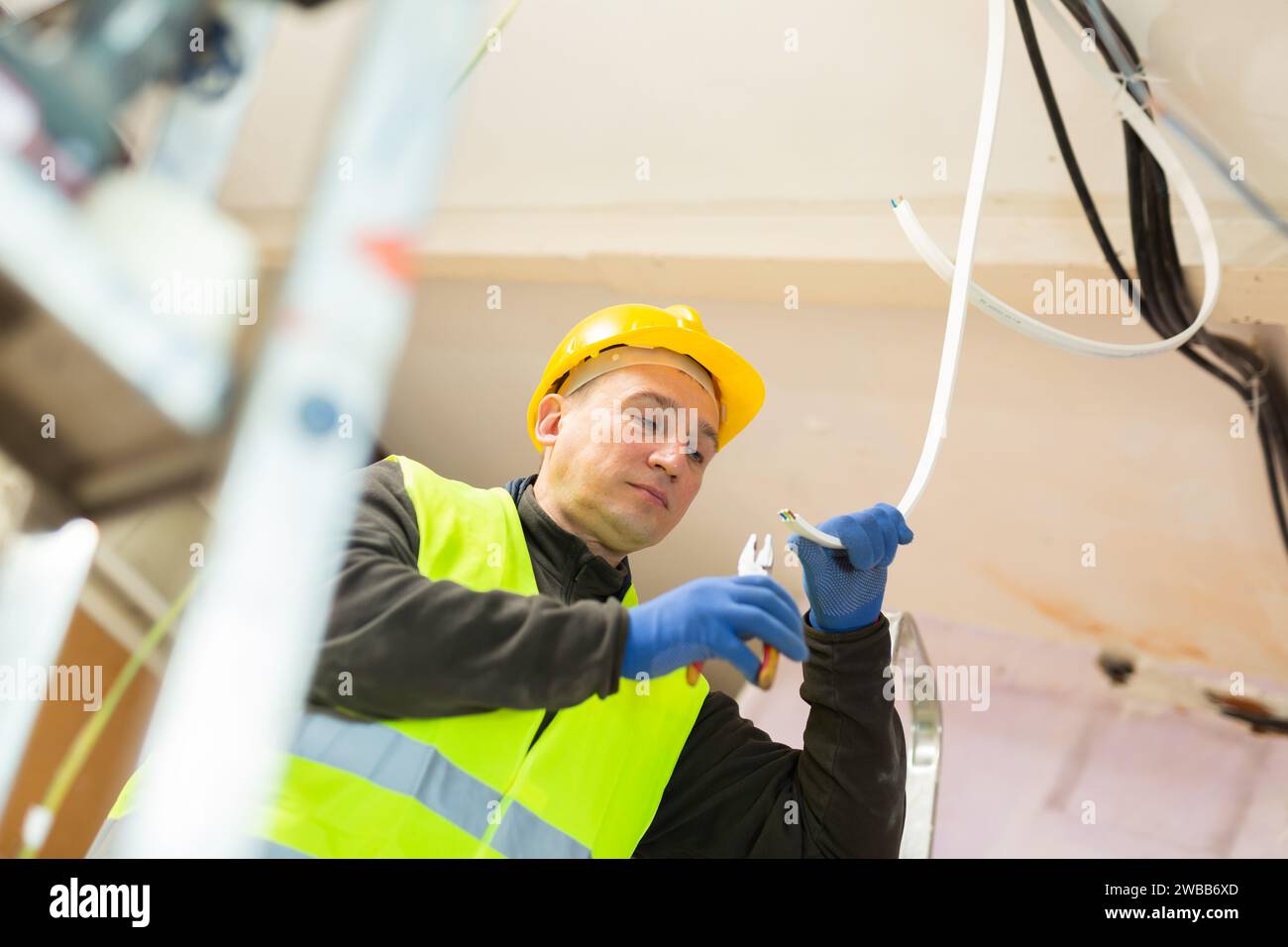 Electrician working with wires in apartment Stock Photo - Alamy