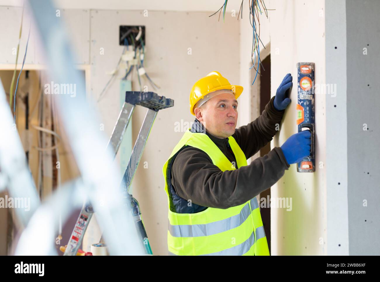 Builder checks vertical level wall hi-res stock photography and images ...