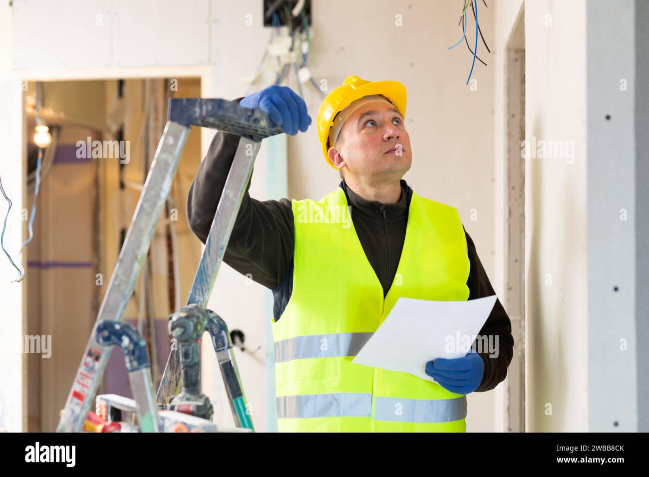 Male contractor looking at room and determining scope of building work ...
