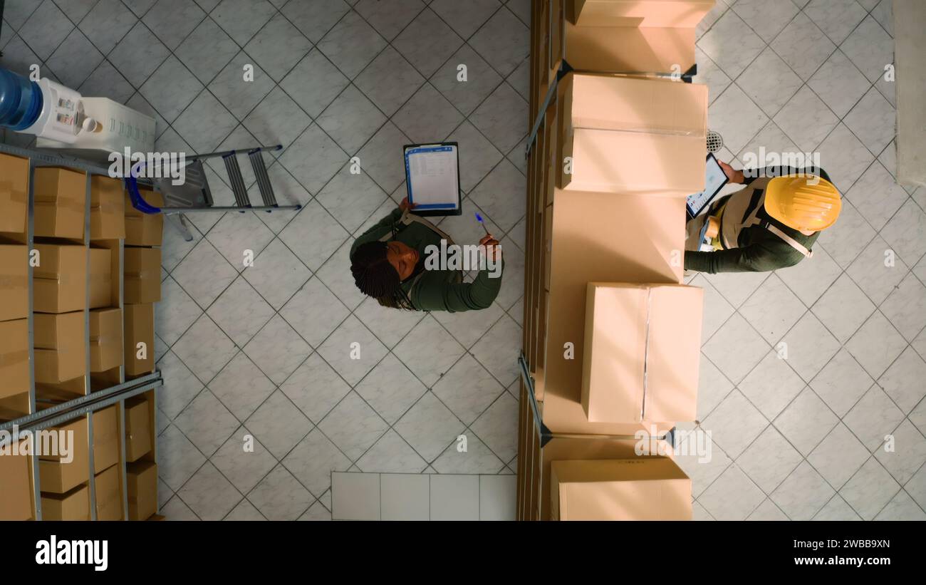 Top down view of logistics coordinators examining cardboard box parcels ...