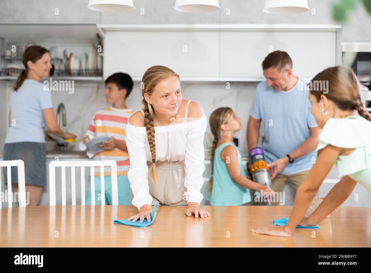 Teenage girls wash dining tables and help to do household chores ...
