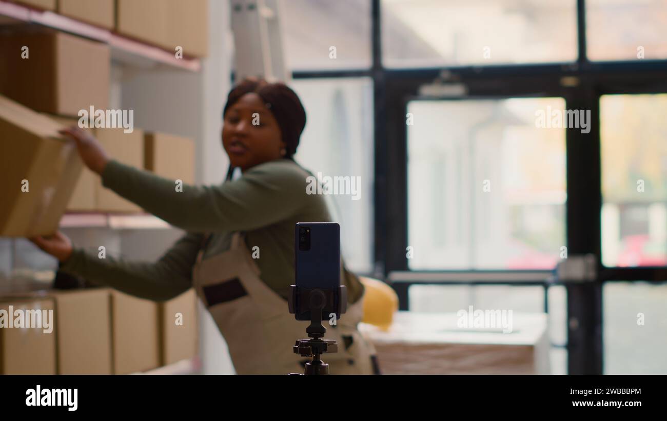 Warehouse advertising professional using smartphone to make branding ...