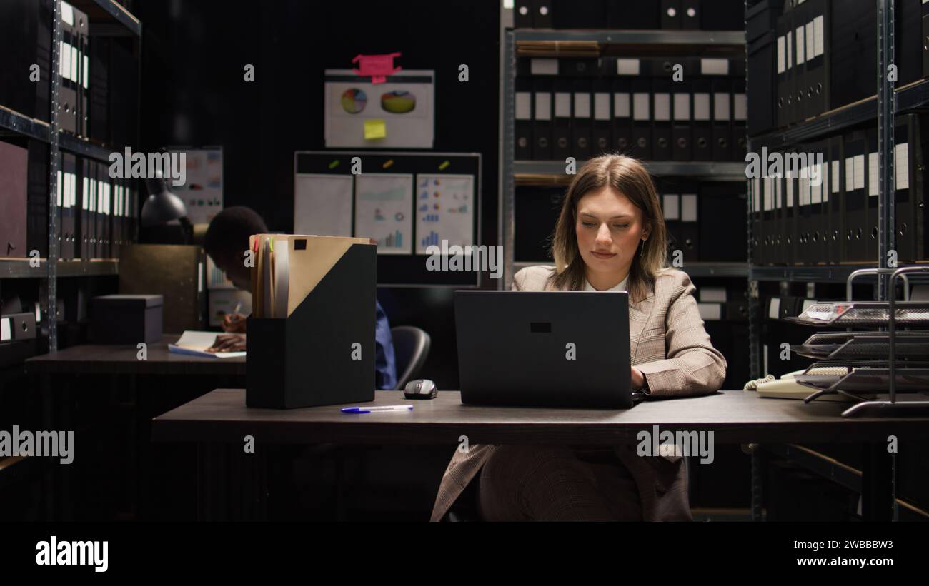 In crime investigation, focused male and female investigators analyzing ...