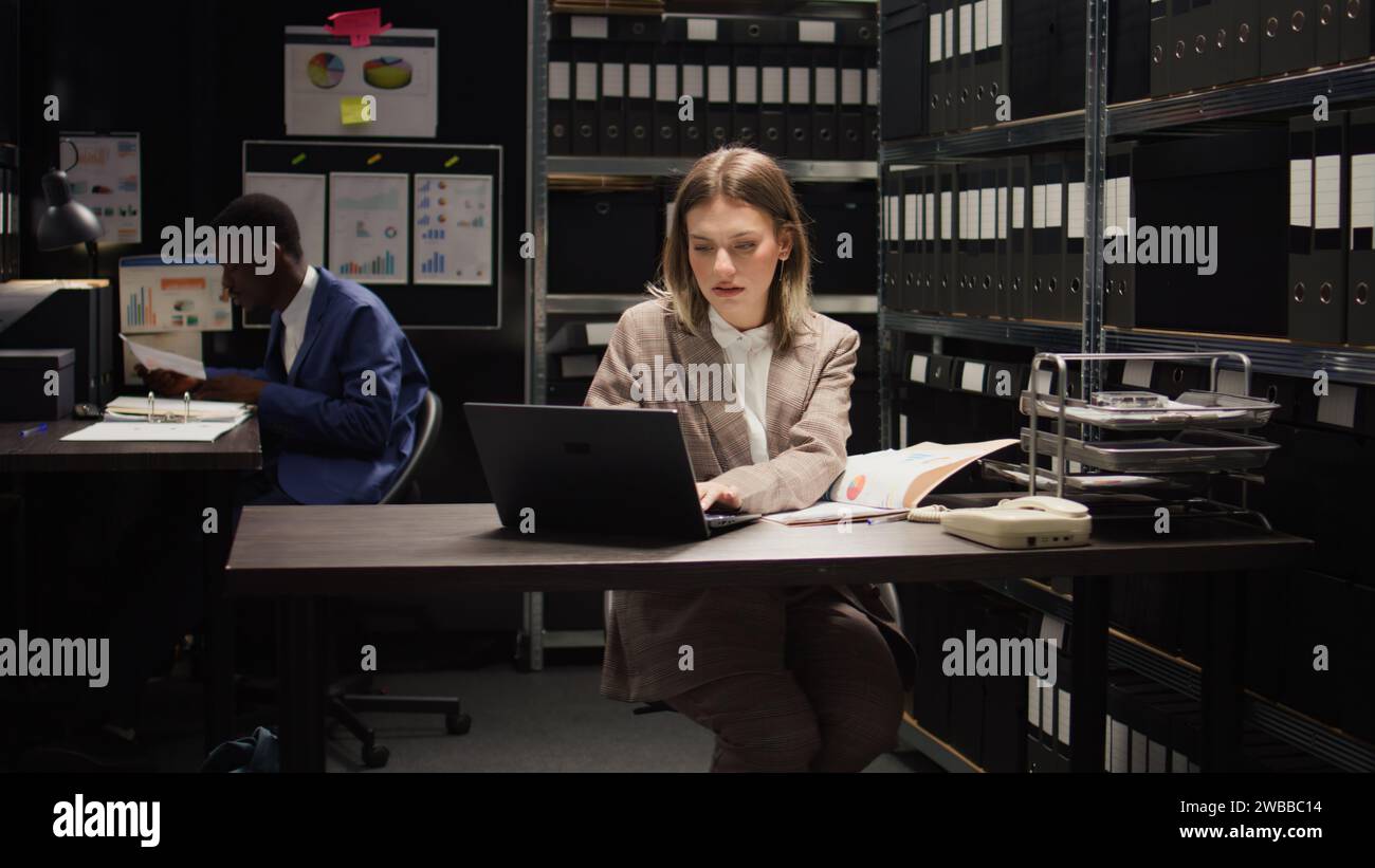 In office, detective inspector and male police officer conduct an ...