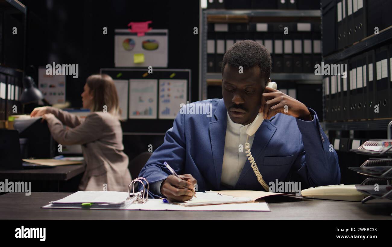 Focus on african american policeman answering phone call and taking ...