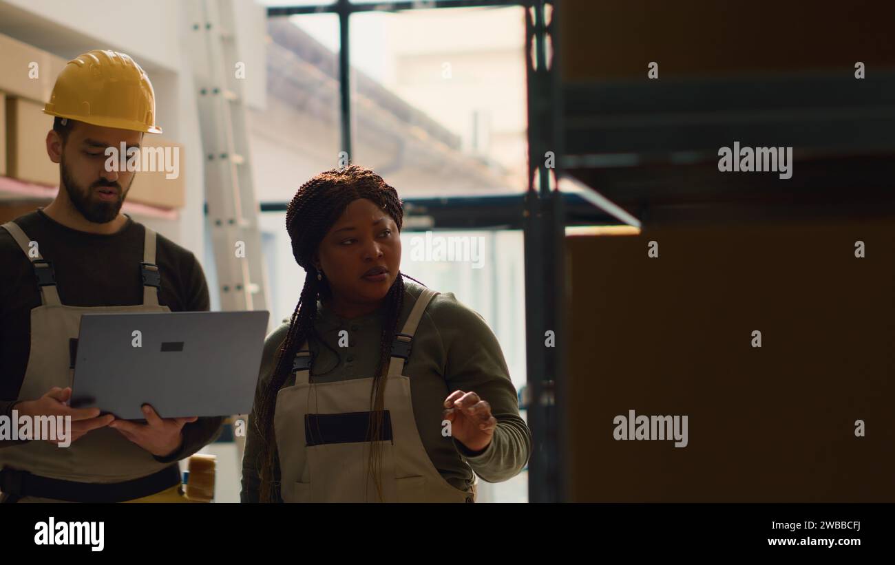 African american logistics director and worker perform warehouse ...