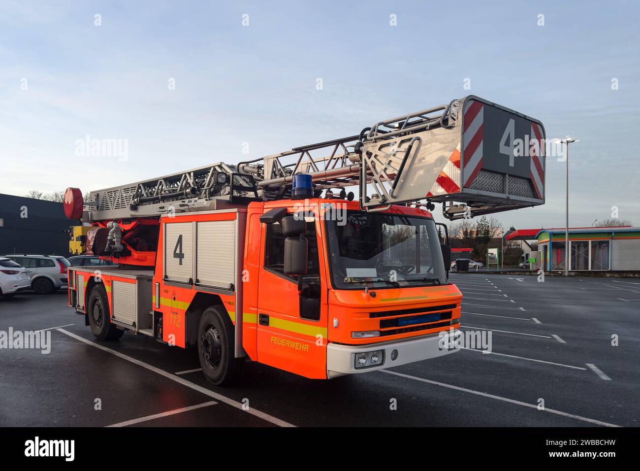 Front view of an orange fire truck standing in a large parking lot ...