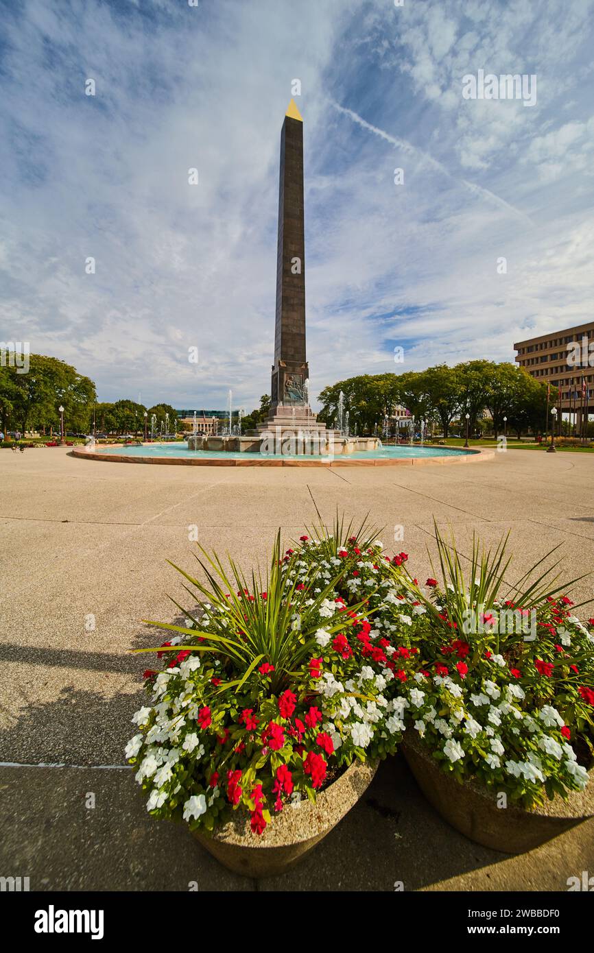 Gleaming Obelisk Monument with Flowers and Fountain in Urban Park Stock ...