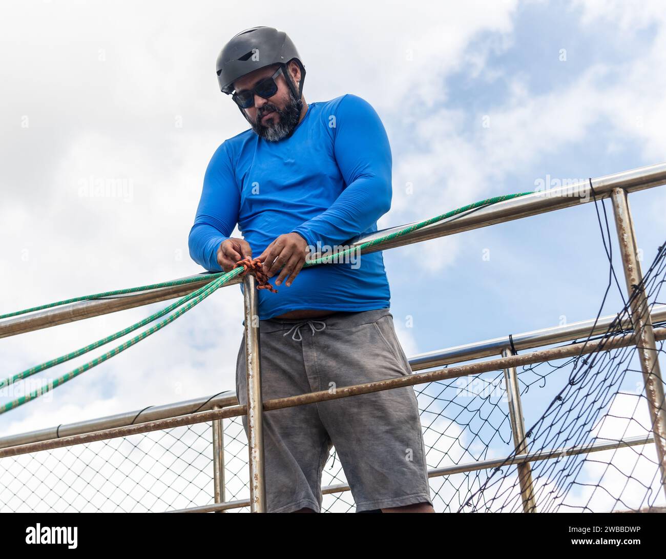 Rappeller carefully checking safety equipment for rappelling. Healthy ...