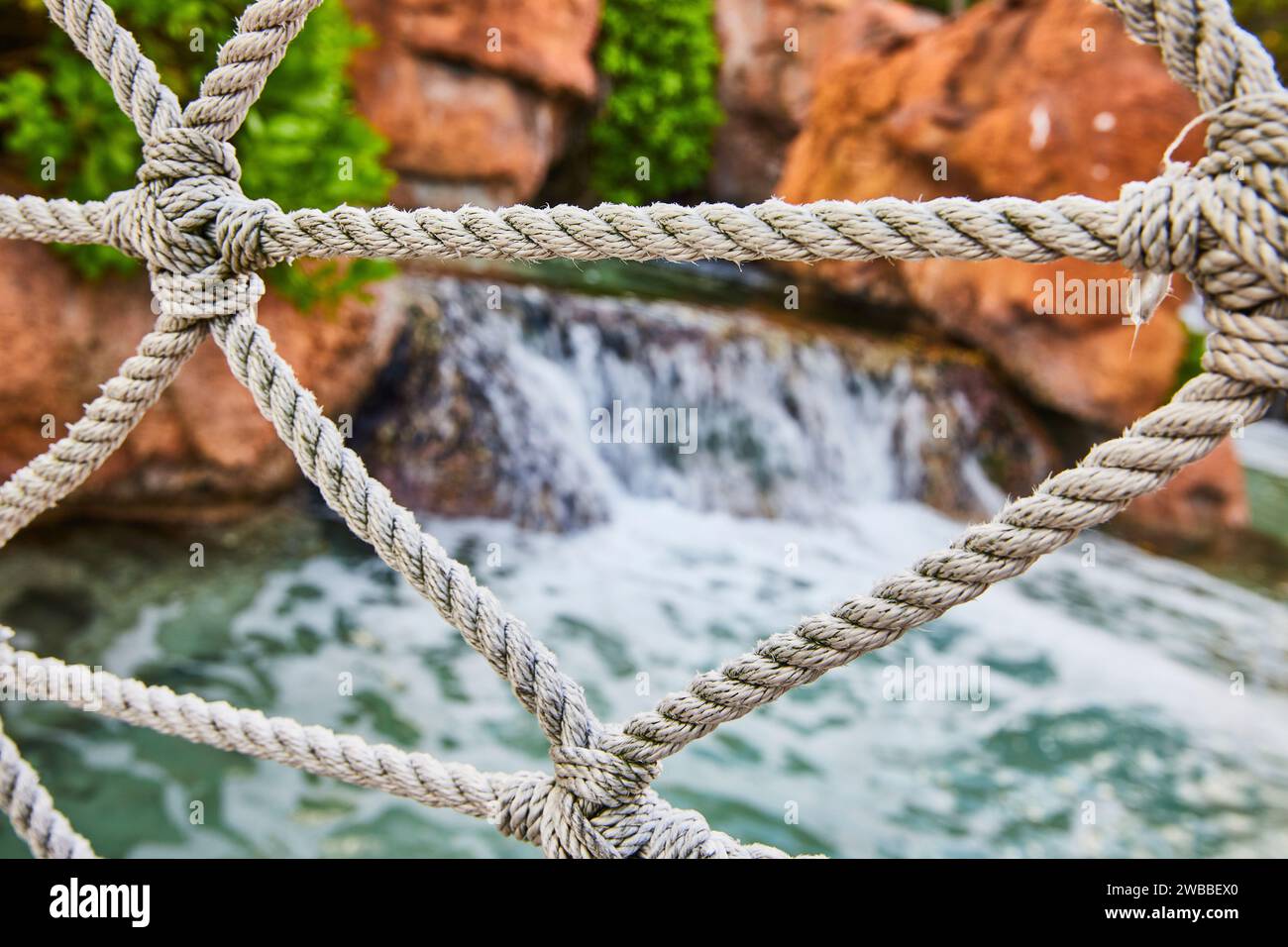Textured Rope Barrier with Waterfall and Greenery Background Stock ...
