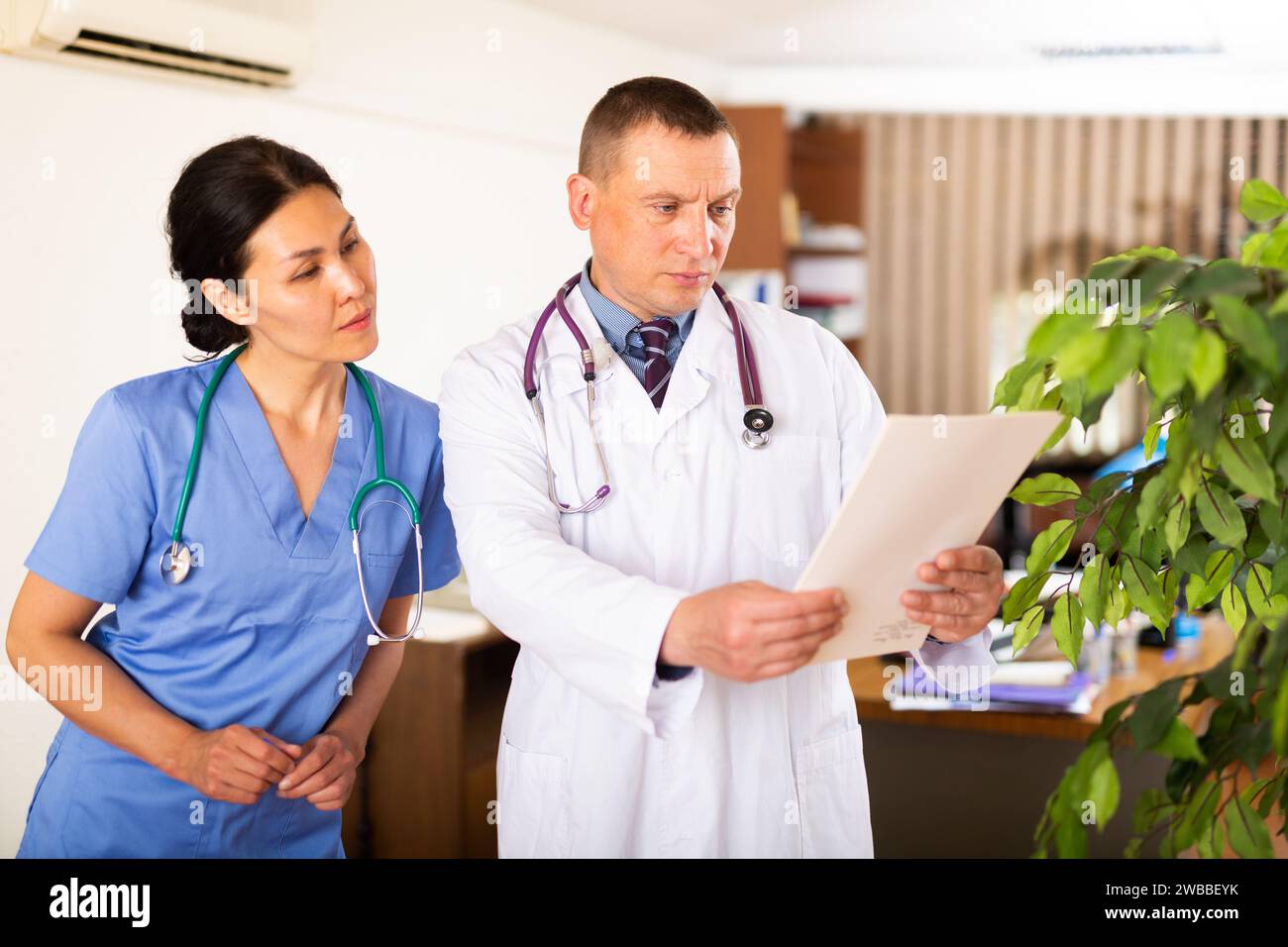 Two doctors checking patient papers in clinic Stock Photo - Alamy