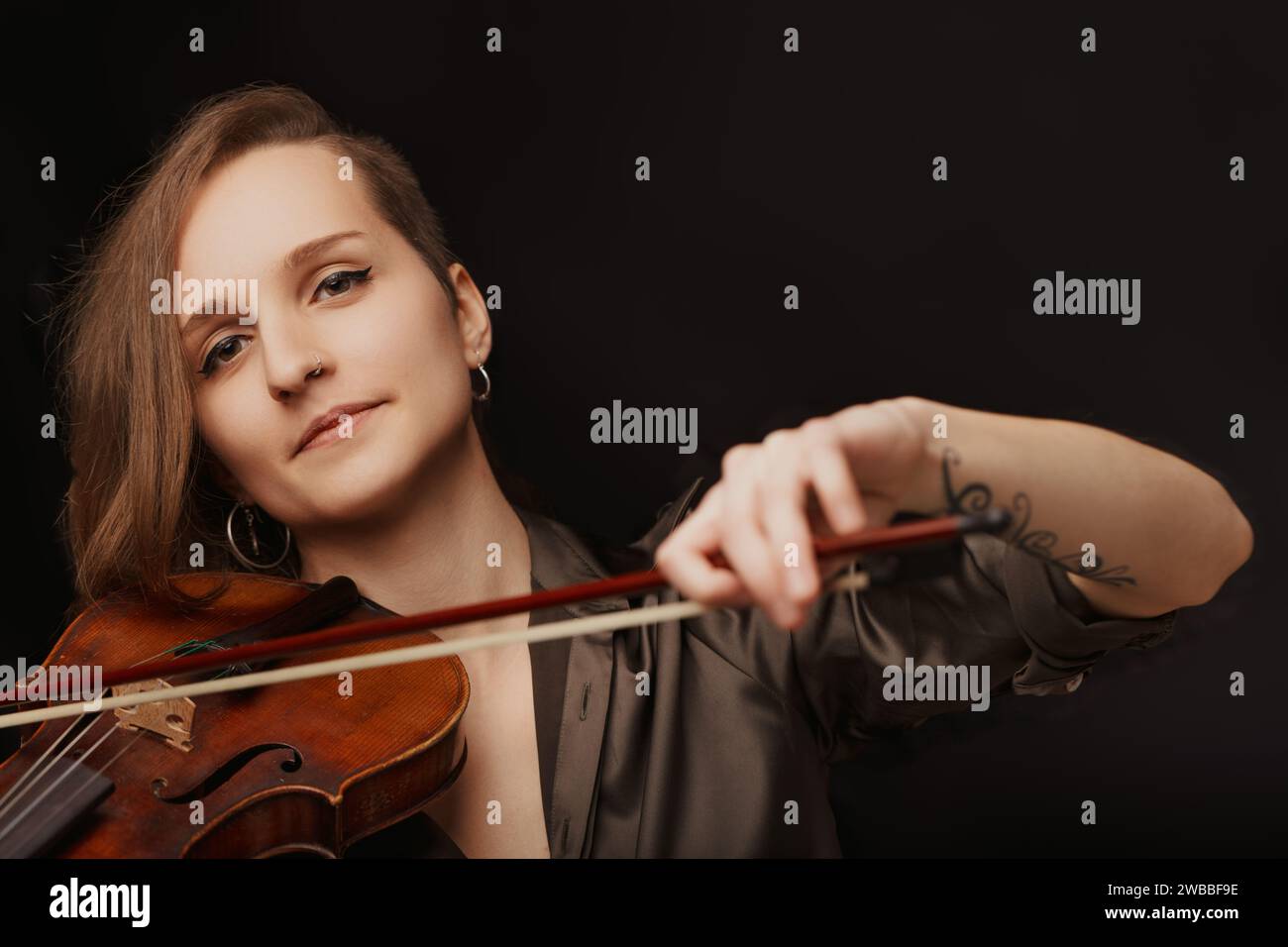 Elegance and skill merge as a woman plays the violin, her expression ...