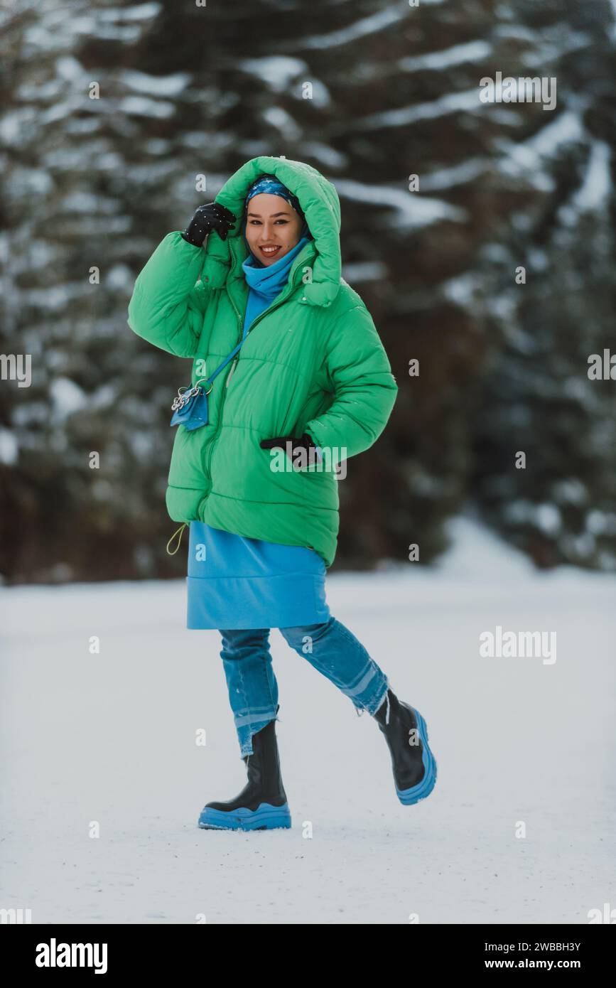 In the breathtaking snowy mountains, a beautiful woman in a hijab and ...