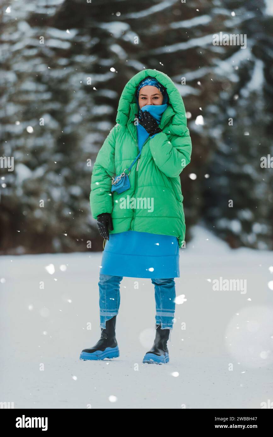 In the breathtaking snowy mountains, a beautiful woman in a hijab and ...