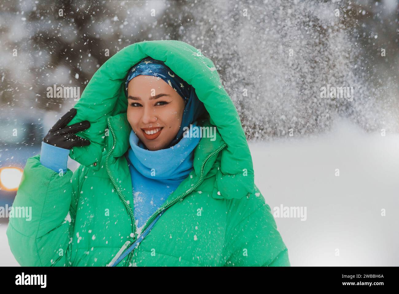In the breathtaking snowy mountains, a beautiful woman in a hijab and ...