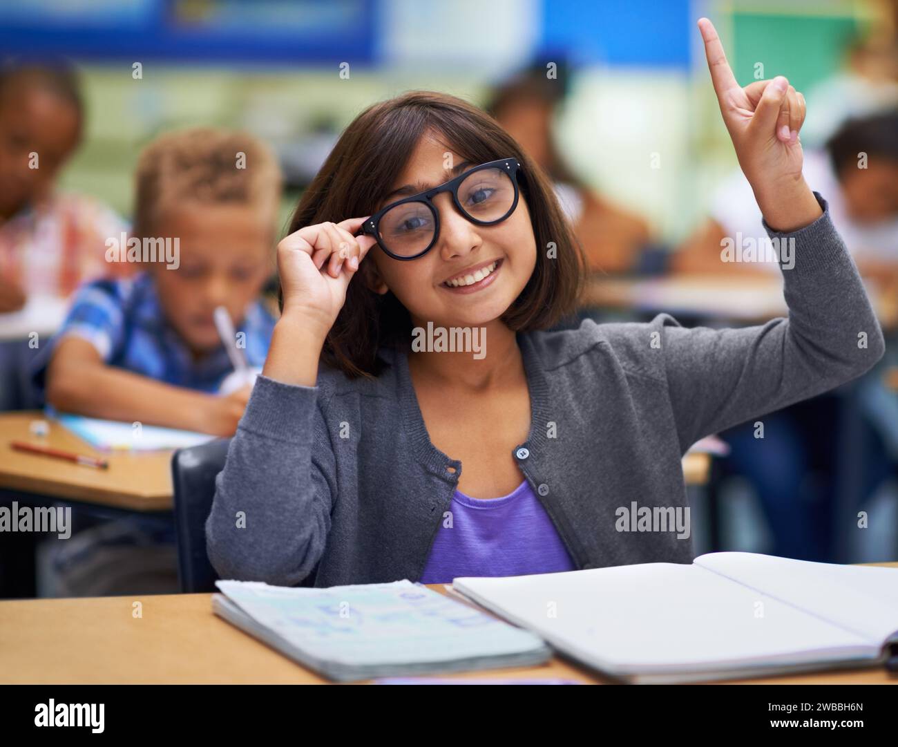 Girl, portrait and raise hand in classroom, primary school and answer ...