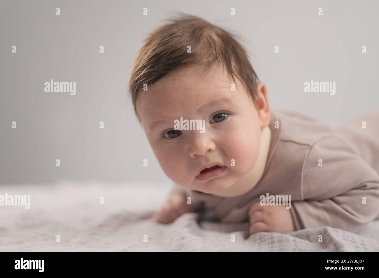 Portrait of a newborn baby lying on his stomach in an orthopedic collar ...