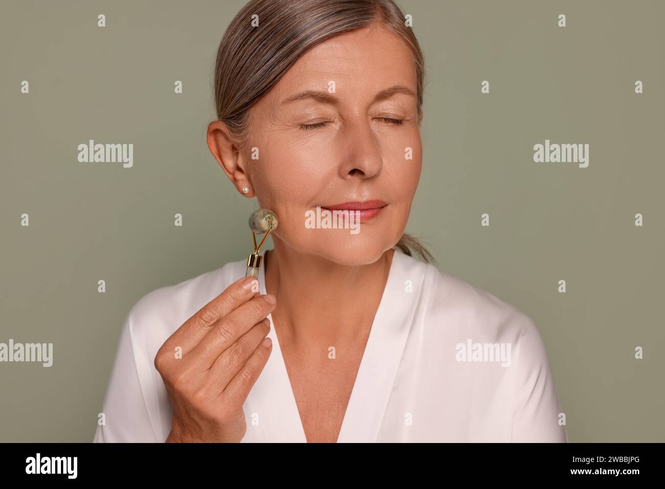Senior woman massaging face roller hi-res stock photography and images ...