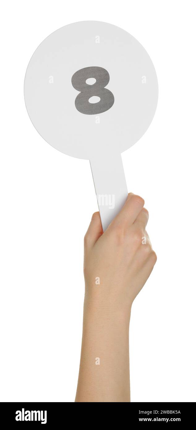 Woman holding auction paddle with number 8 on white background, closeup ...