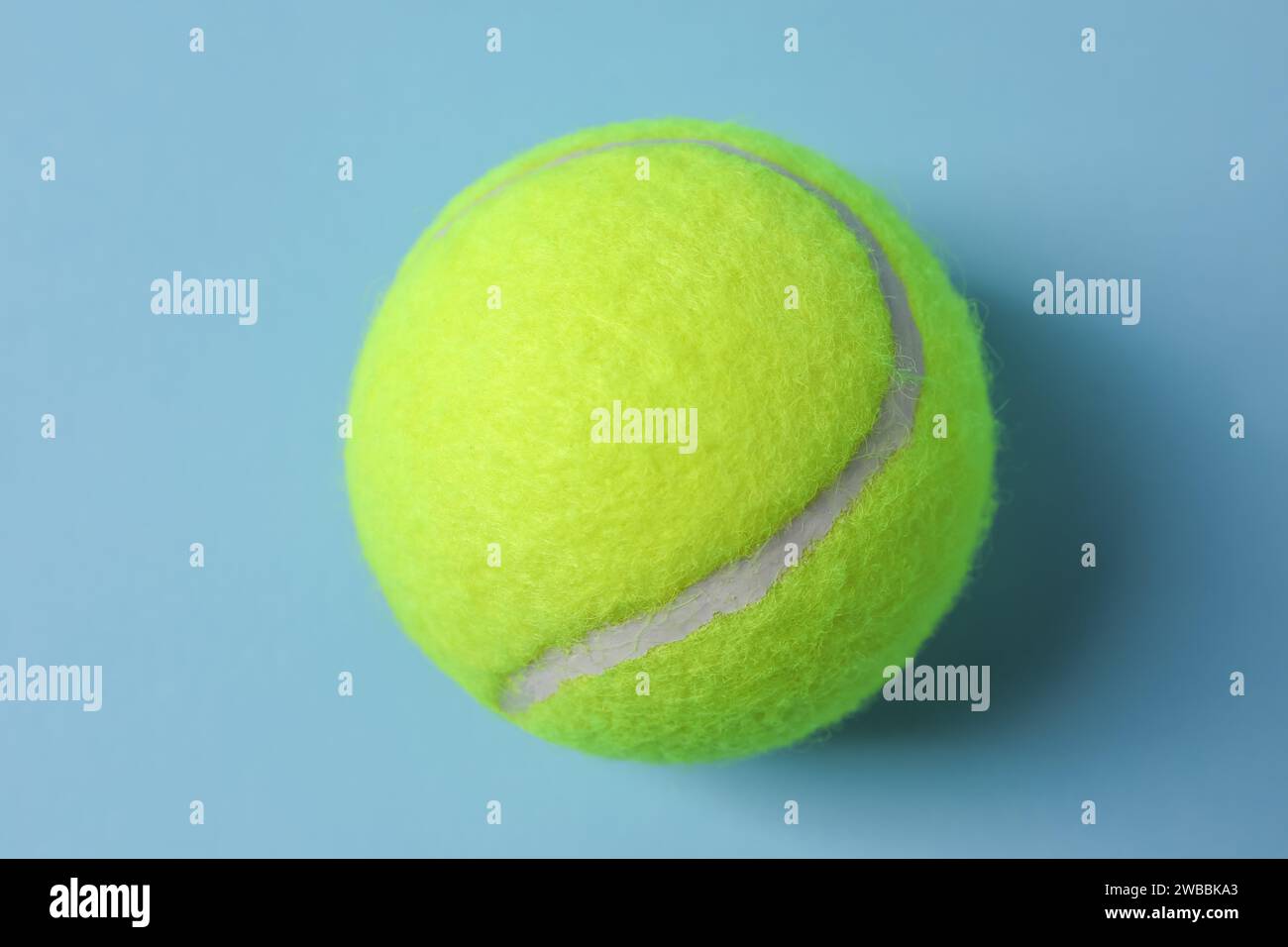One tennis ball on light blue background, top view Stock Photo - Alamy
