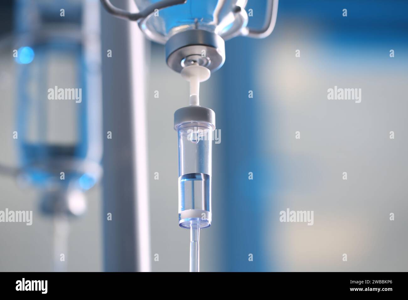 IV drip chamber against blurred light background Stock Photo - Alamy