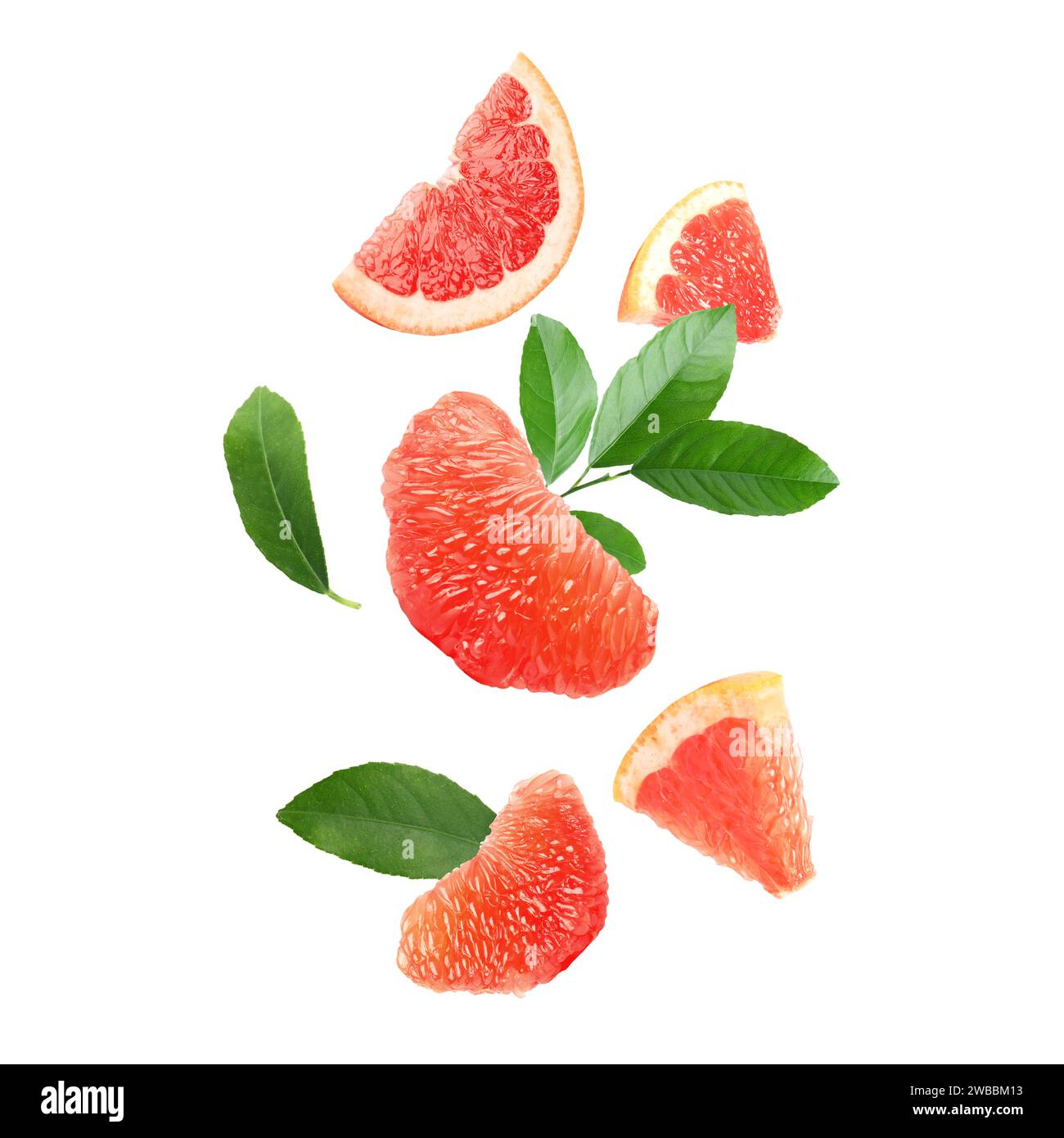 Fresh grapefruit pieces and green leaves falling on white background ...