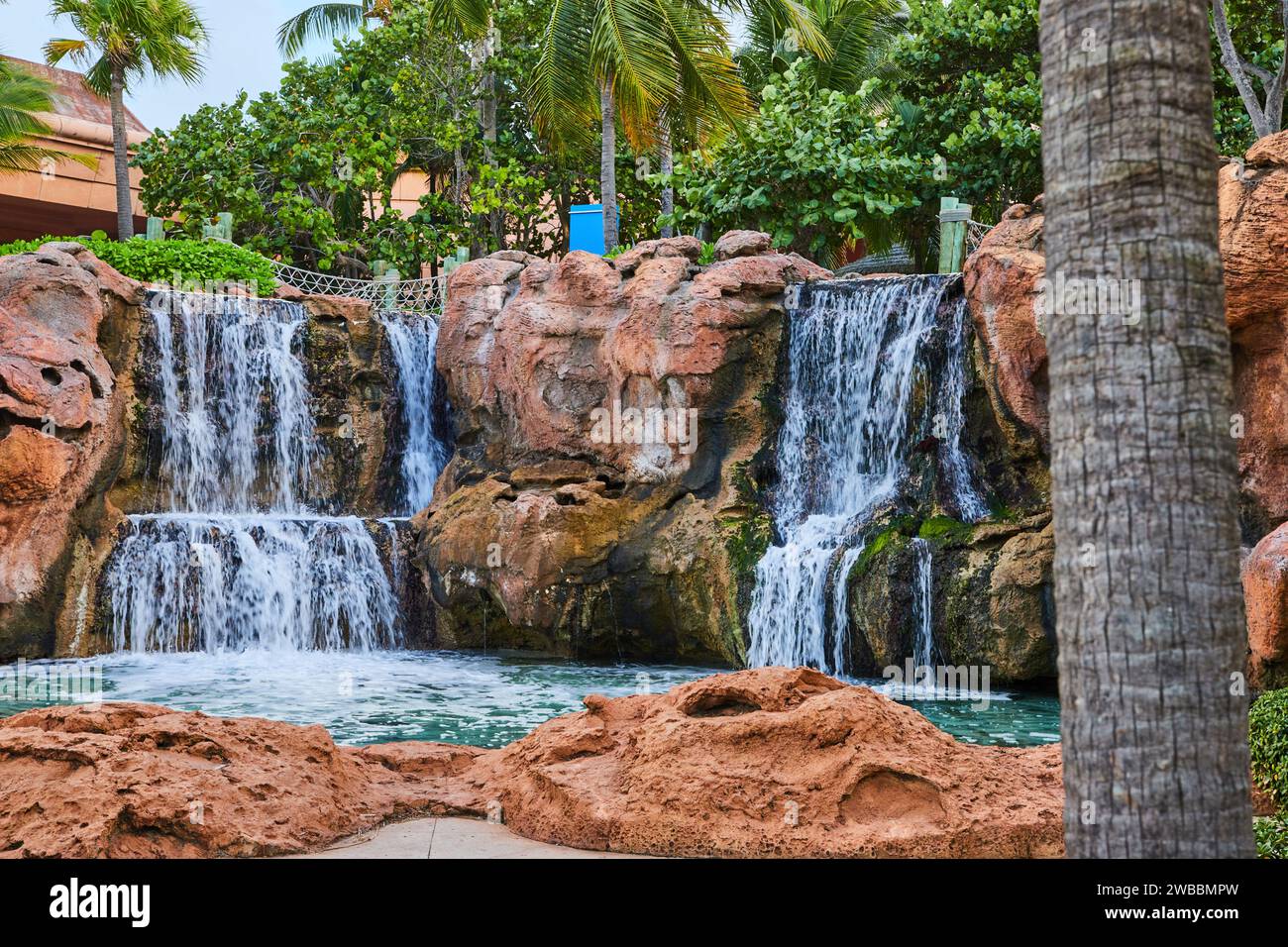 Serene Man-Made Waterfall in Lush Tropical Oasis Stock Photo - Alamy