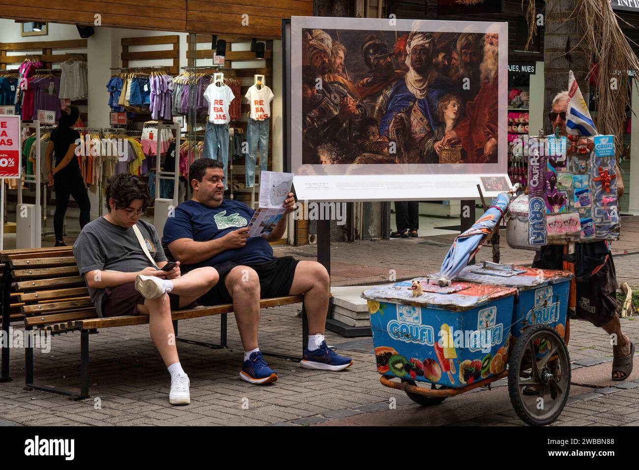 A popsicle vendor pushes his cart past a replica of The Adoration of ...