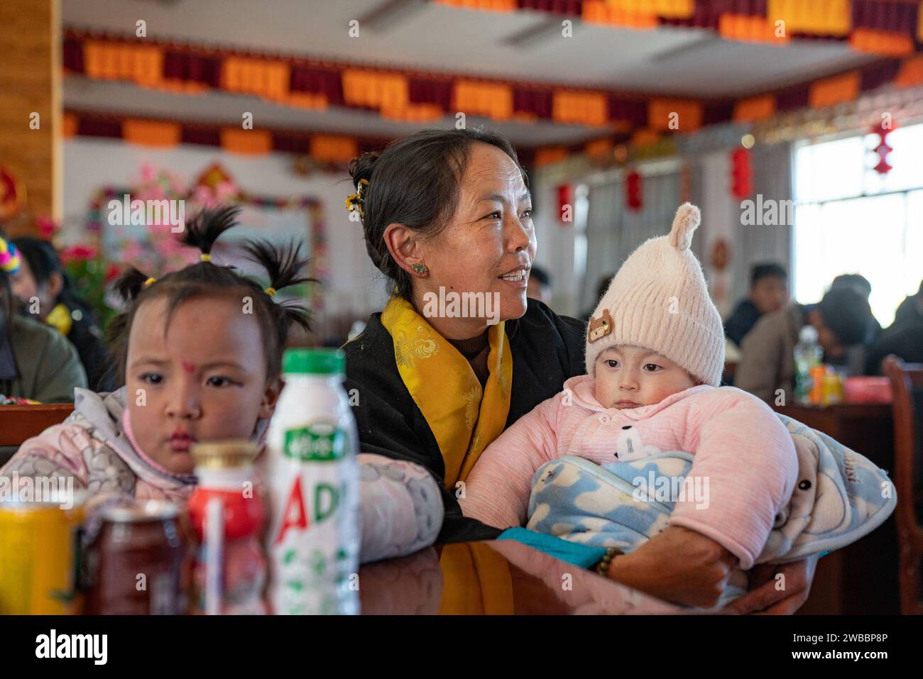 (240109) -- LHASA, Jan. 9, 2024 (Xinhua) -- Pasang holds a baby at a ...