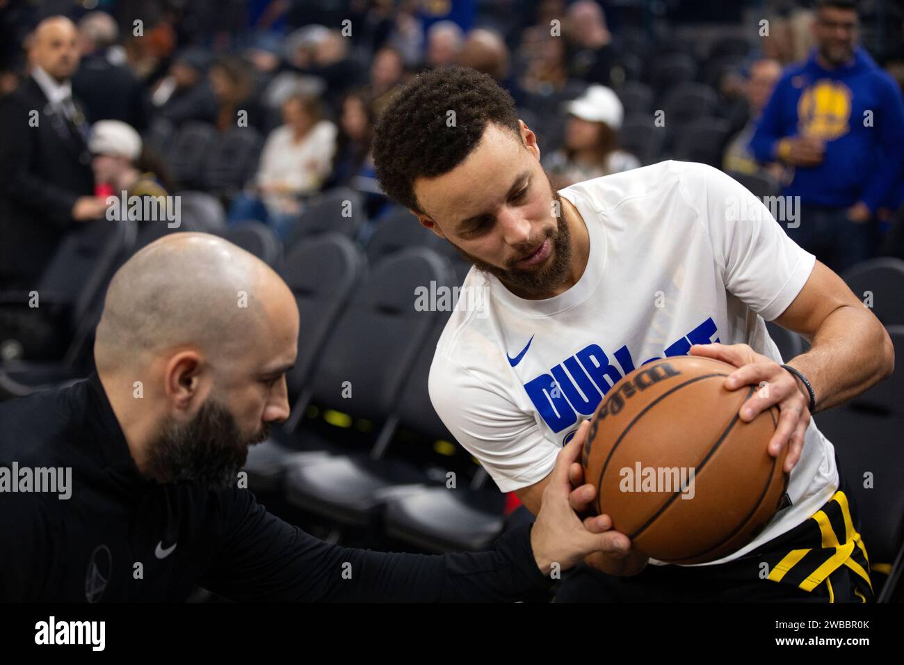 Golden State Warriors guard Stephen Curry, right, warms up with a team trainer before an NBA ...