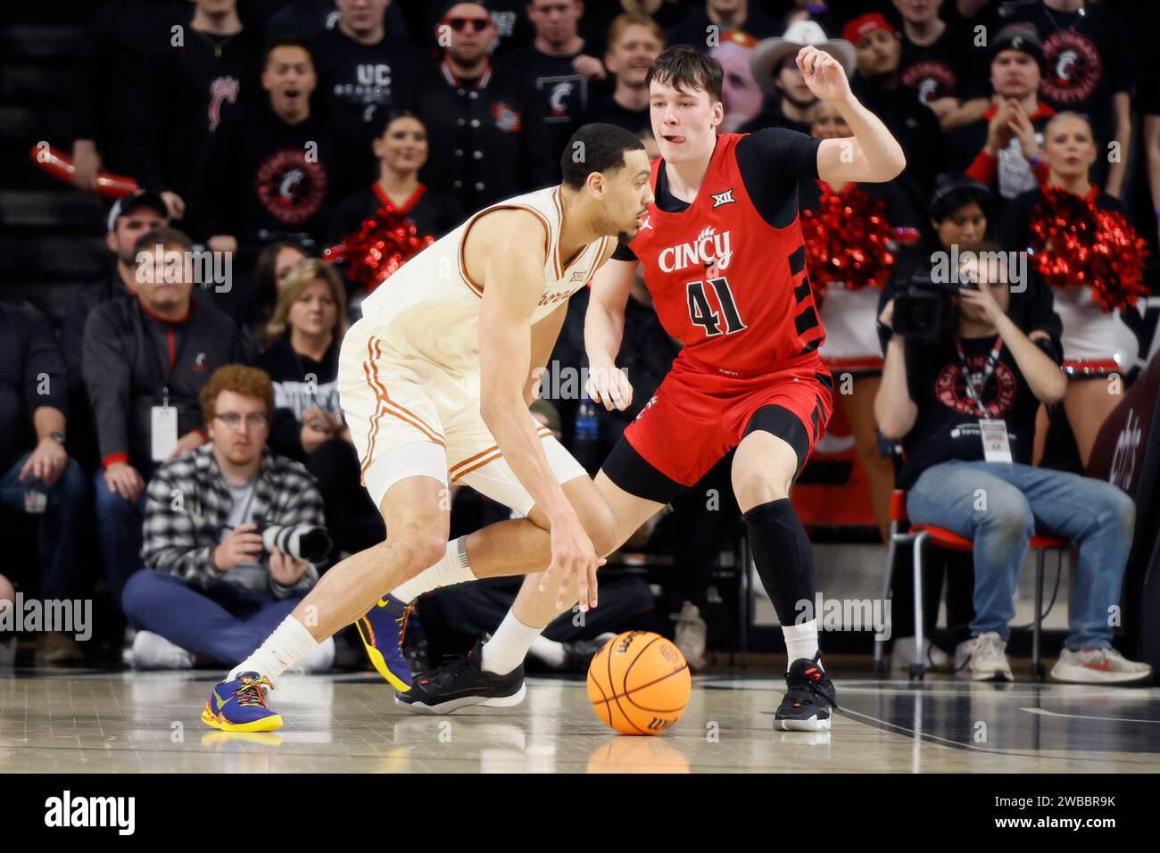 Texas' Dylan Disu, left, is defended by Cincinnati's Simas Lukosius ...