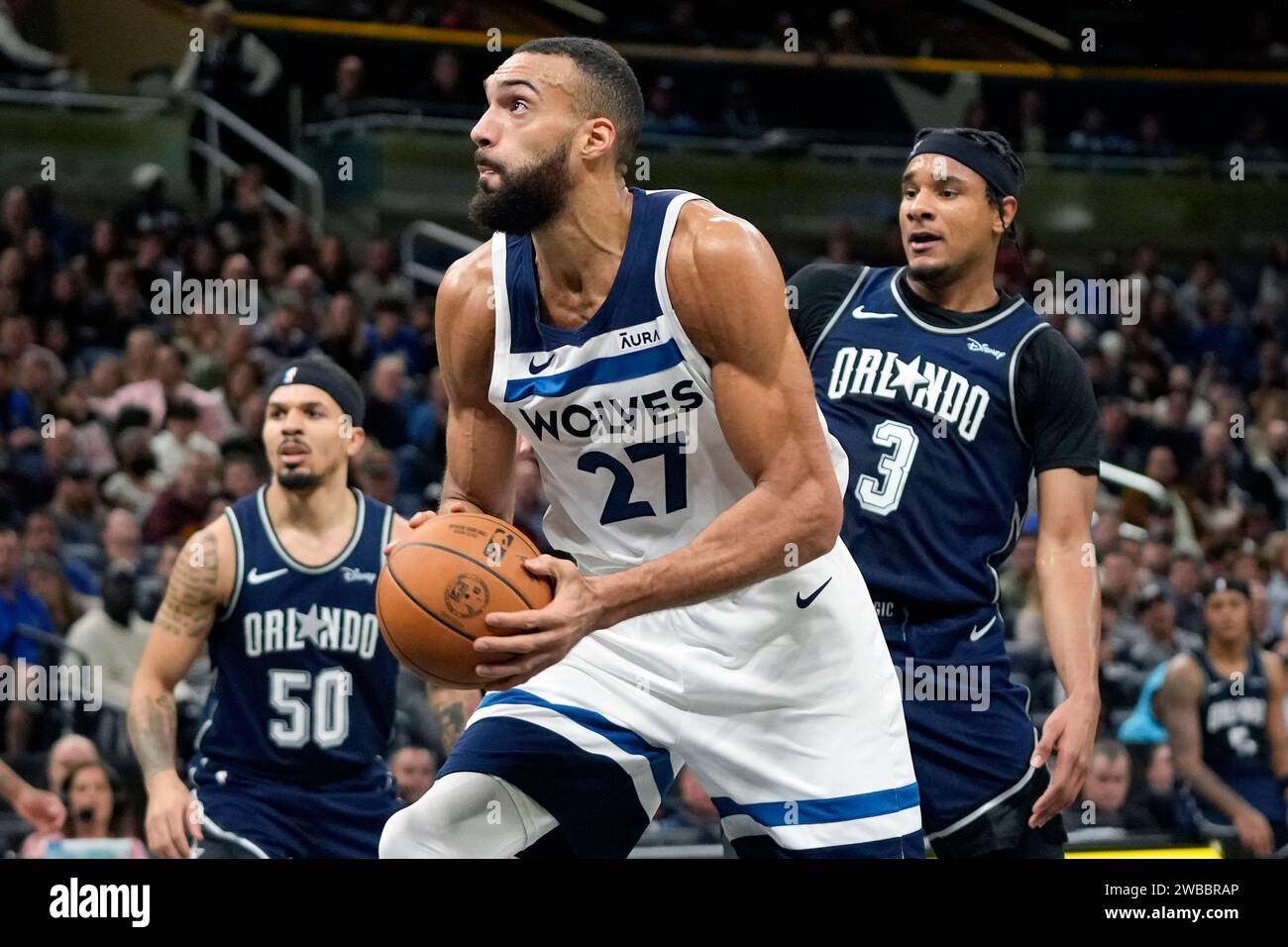 Minnesota Timberwolves center Rudy Gobert (27) goes past Orlando Magic guard Cole Anthony (50 ...