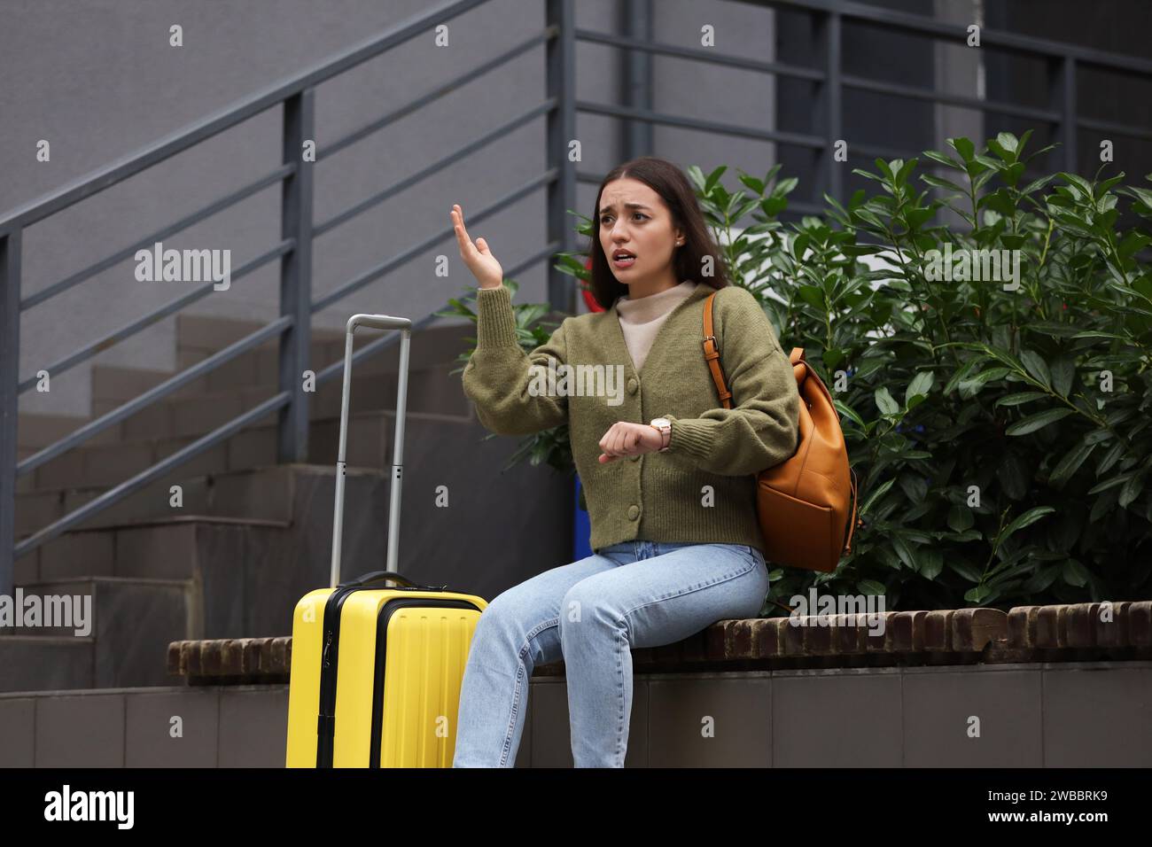 Being late. Worried woman with suitcase sitting on bench outdoors Stock ...