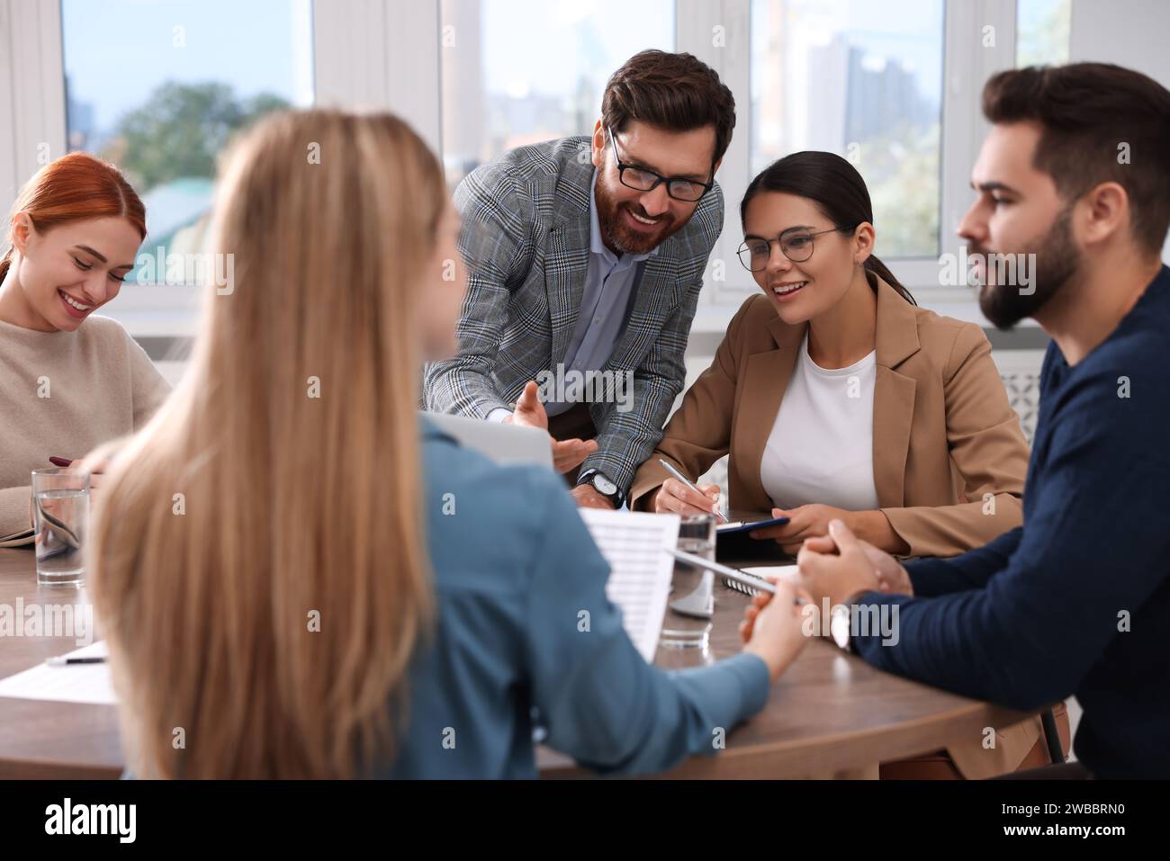 Team of employees working together in office Stock Photo - Alamy