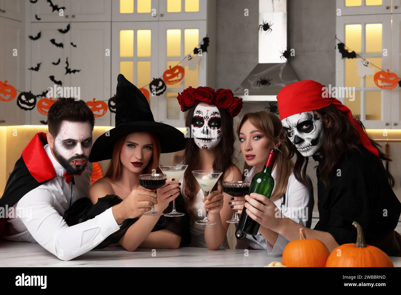 Group of people in scary costumes with cocktails celebrating Halloween ...