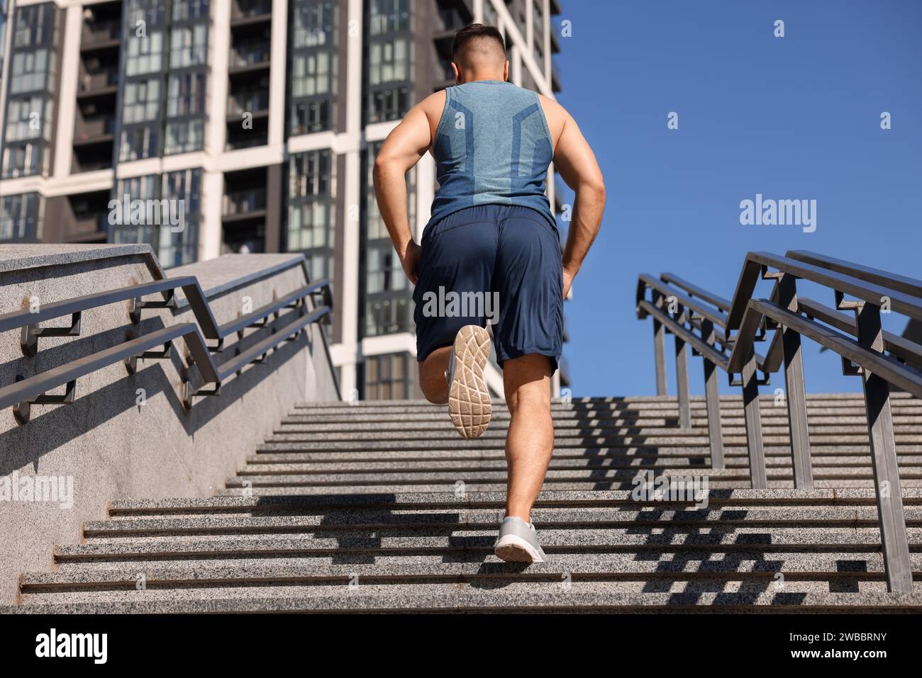 Man running up stairs outdoors on sunny day, back view Stock Photo - Alamy