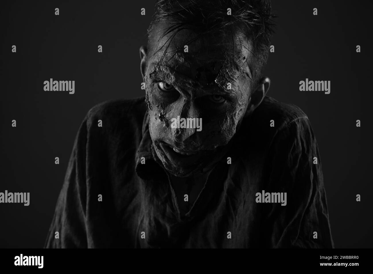 Scary zombie on dark background, black and white effect. Halloween ...