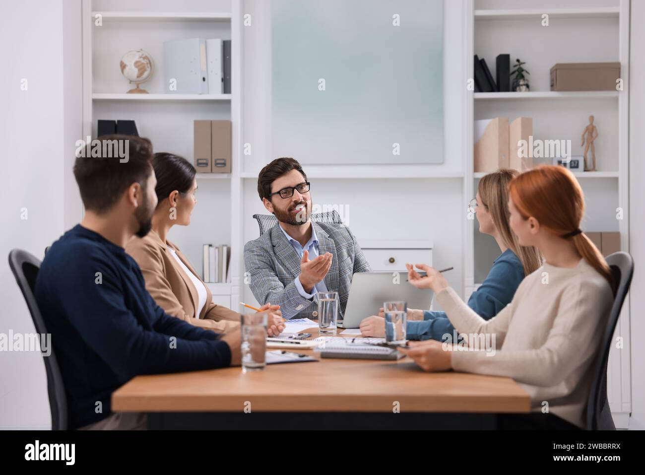 Team of employees working together in office Stock Photo - Alamy